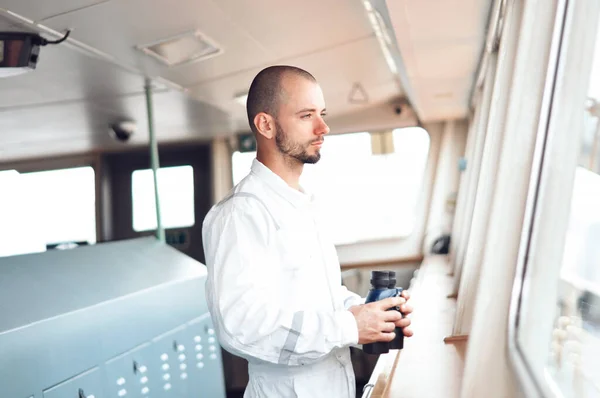 Sailor navigator, the third assistant to the captain looks through ...