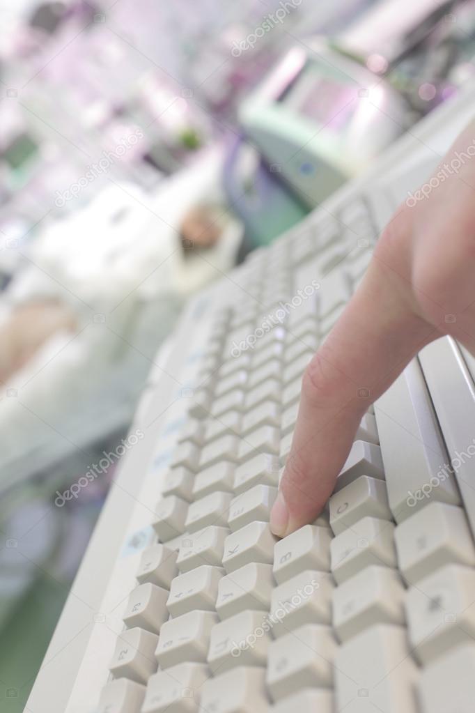 Doctor typing on keyboard in patients ward Stock Photo by ©sudok1 81267452