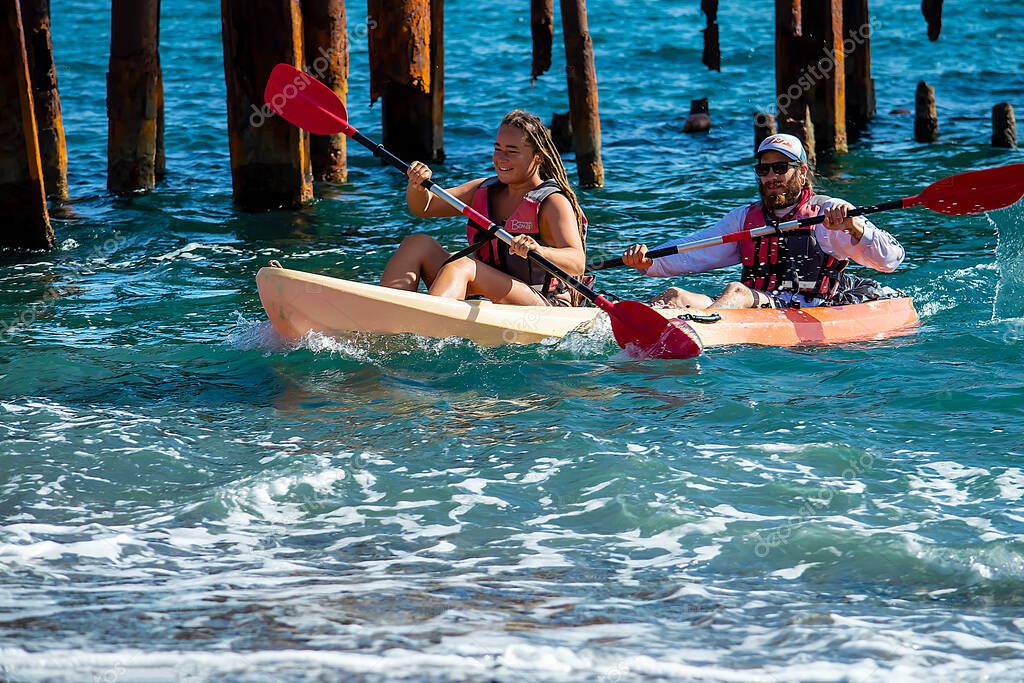 Un hombre y una mujer en un kayak en el mar cerca de la orilla. Vista ...
