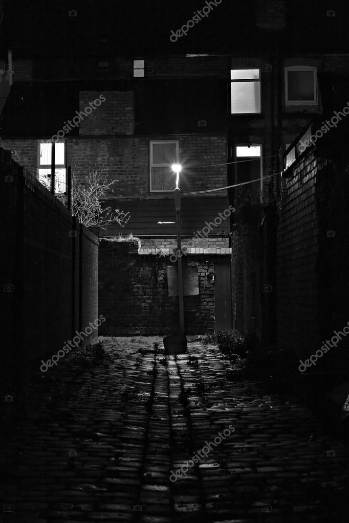 Dark inner city cobblestoned back alley with streetlight at night Stock ...
