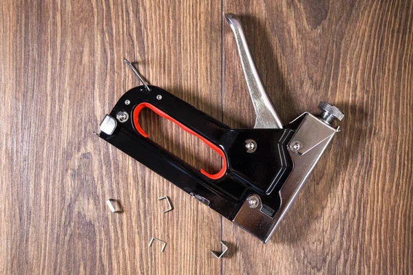 Close up carpentry stapler with staples on wood background — Stock ...