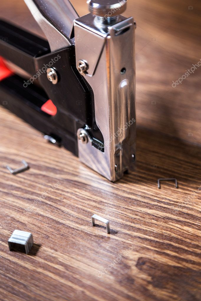 Close up carpentry stapler with staples on wood background — Stock ...