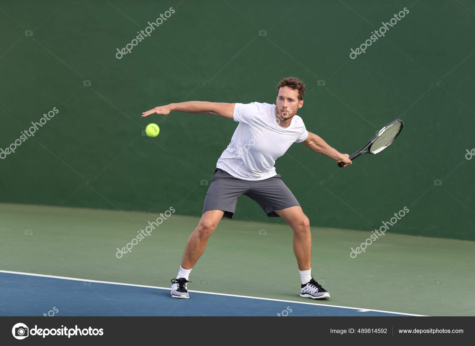 Professional tennis player athlete man hitting forehand ball on hard ...