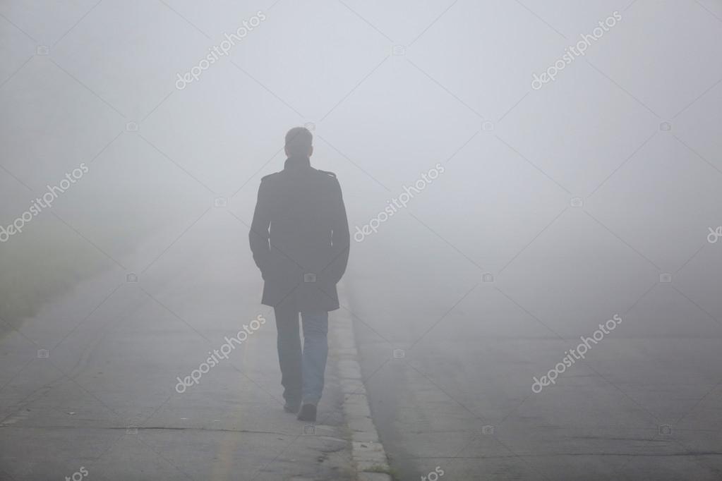 Man with his back walking through the fog street — Stock Photo ...