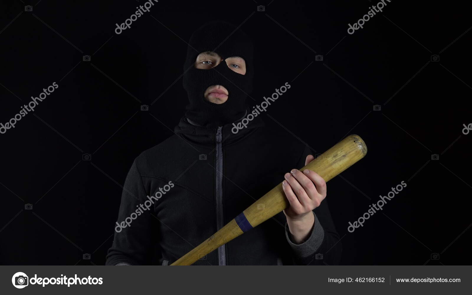 A man in a balaclava mask is standing with a baseball bat. A gangster ...