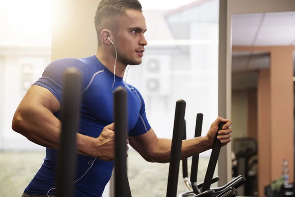 man on elliptical trainer in gym - Stock Image - Everypixel
