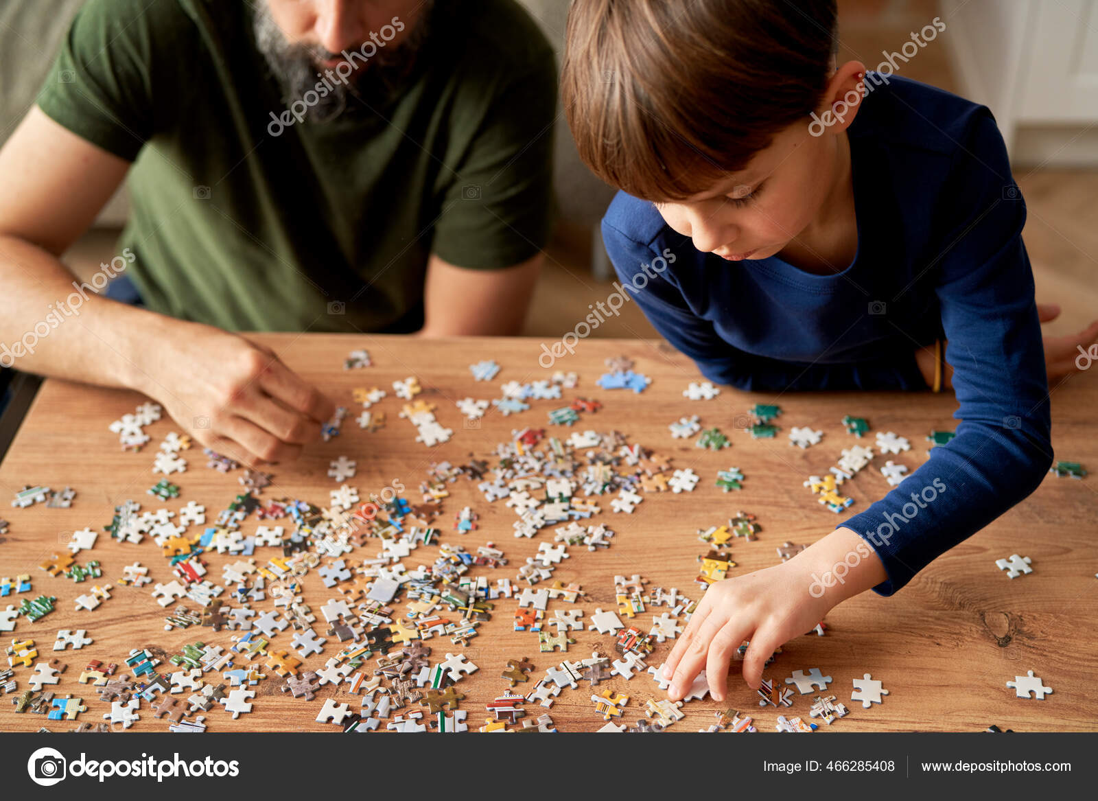 Top View Solving Jigsaw Puzzle Table Stock Photo by ©gpointstudio 466285408
