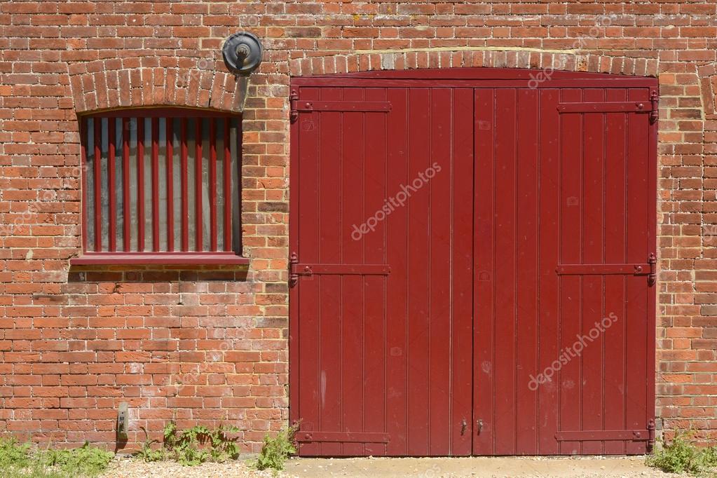 Red door and window in brick wall — Stock Photo © clickos #59266039