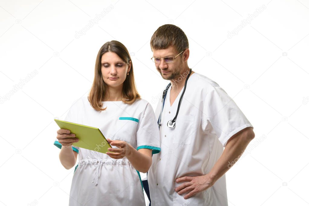Médico y enfermera discutiendo las pruebas del paciente, mirando ...