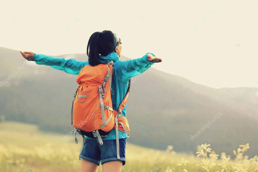 Woman backpacker in grassland Stock Photo by ©lzf 118477508