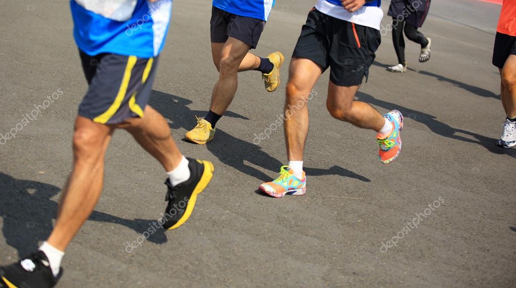 Marathon athletes legs running on city road Stock Photo by ©lzf 59567383