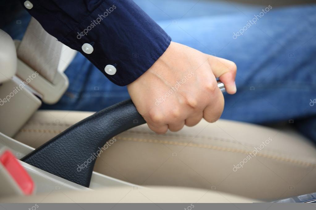 Driver pulling the hand brake in car Stock Photo by ©lzf 60098401