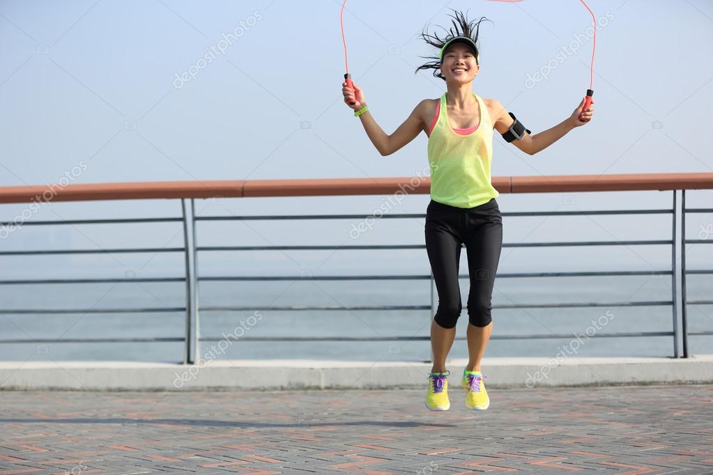 Woman jumping with rope Stock Photo by ©lzf 92324020