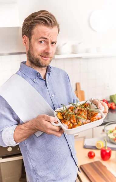 Man or chef holding roasting dish with raw chicken drumsticks Stock ...