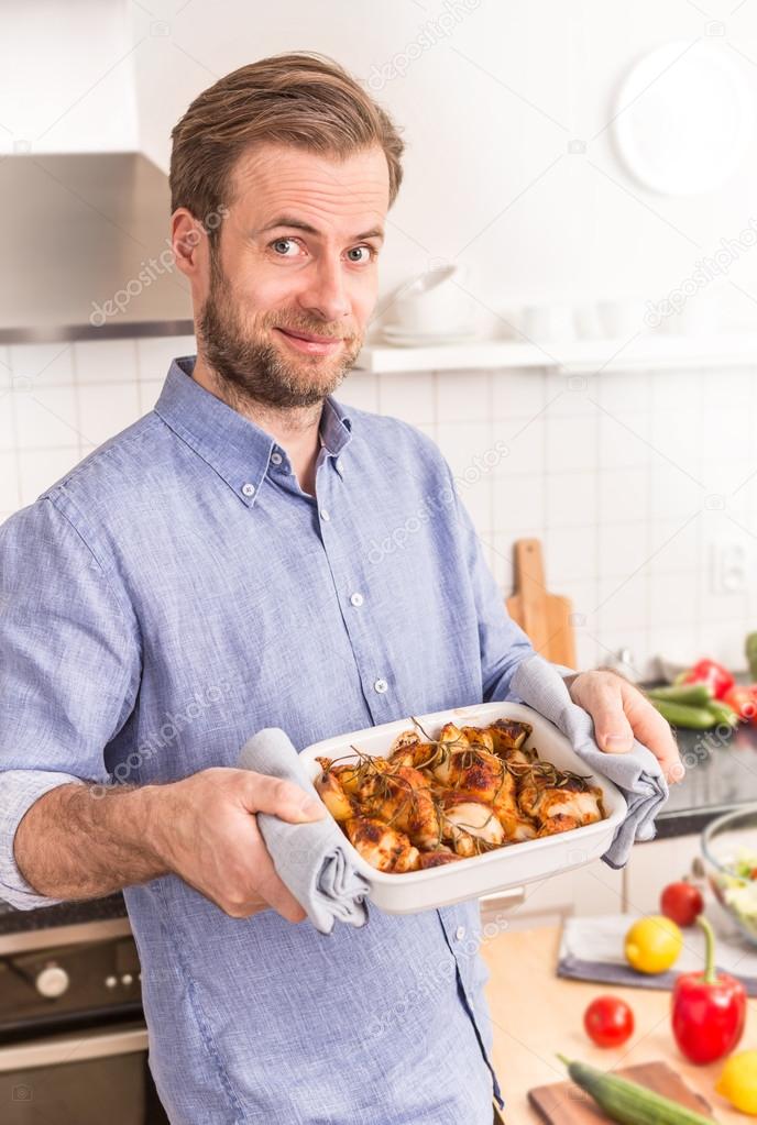 Man or chef holding roasting dish with hot chicken drumsticks Stock ...