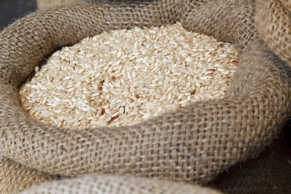 Rice in jute sack — Stock Photo © Veljanovski #53678489