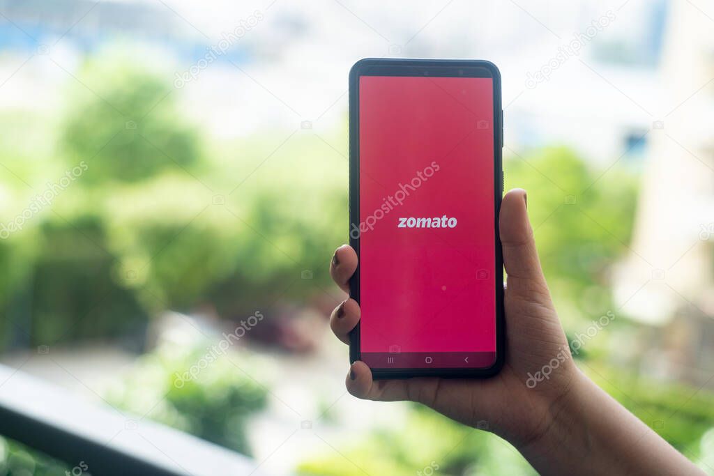 mano sosteniendo un tel fono m vil con el logotipo de la aplicaci n zomato que muestra este ...
