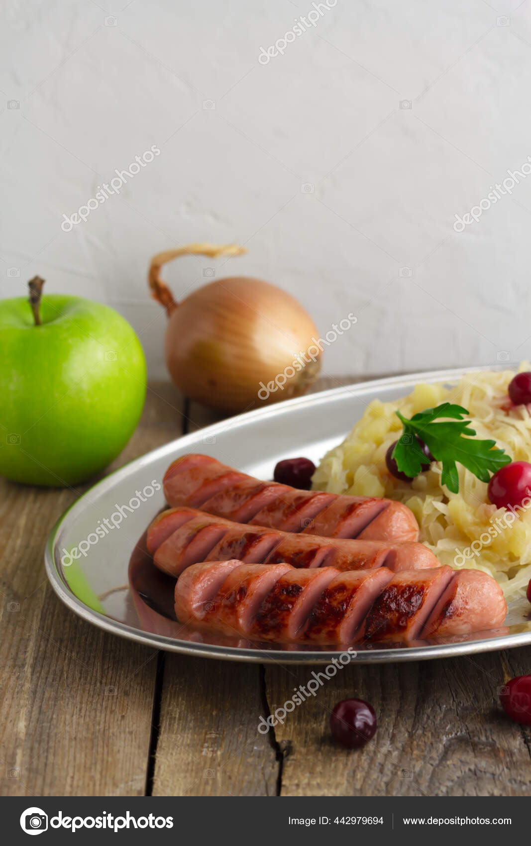 Stewed fermented cabbage with roasted sausages on rustic background ...