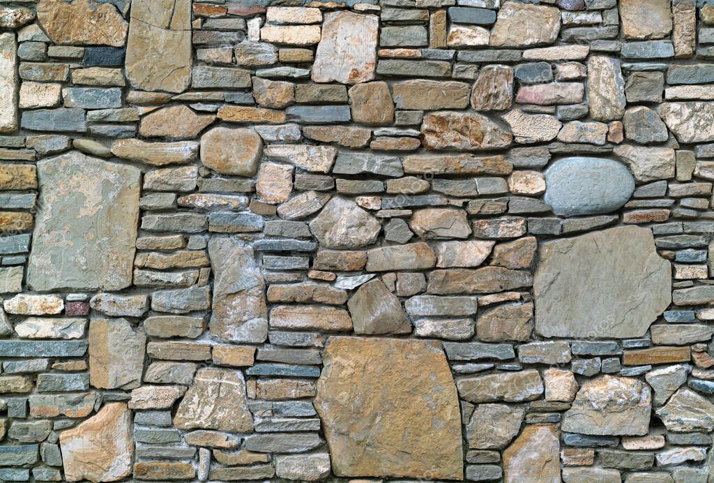 Pared de revestimiento de piedra hecha de losas apiladas a rayas de ...