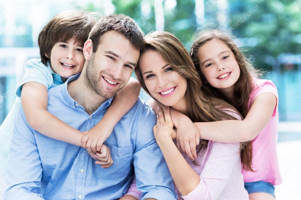 Happy young family hugging Stock Photo by ©pikselstock 76180601