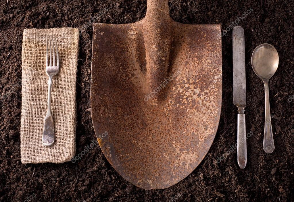 Rusted shovel on soil background with fork, knife, spoon, and na Stock ...