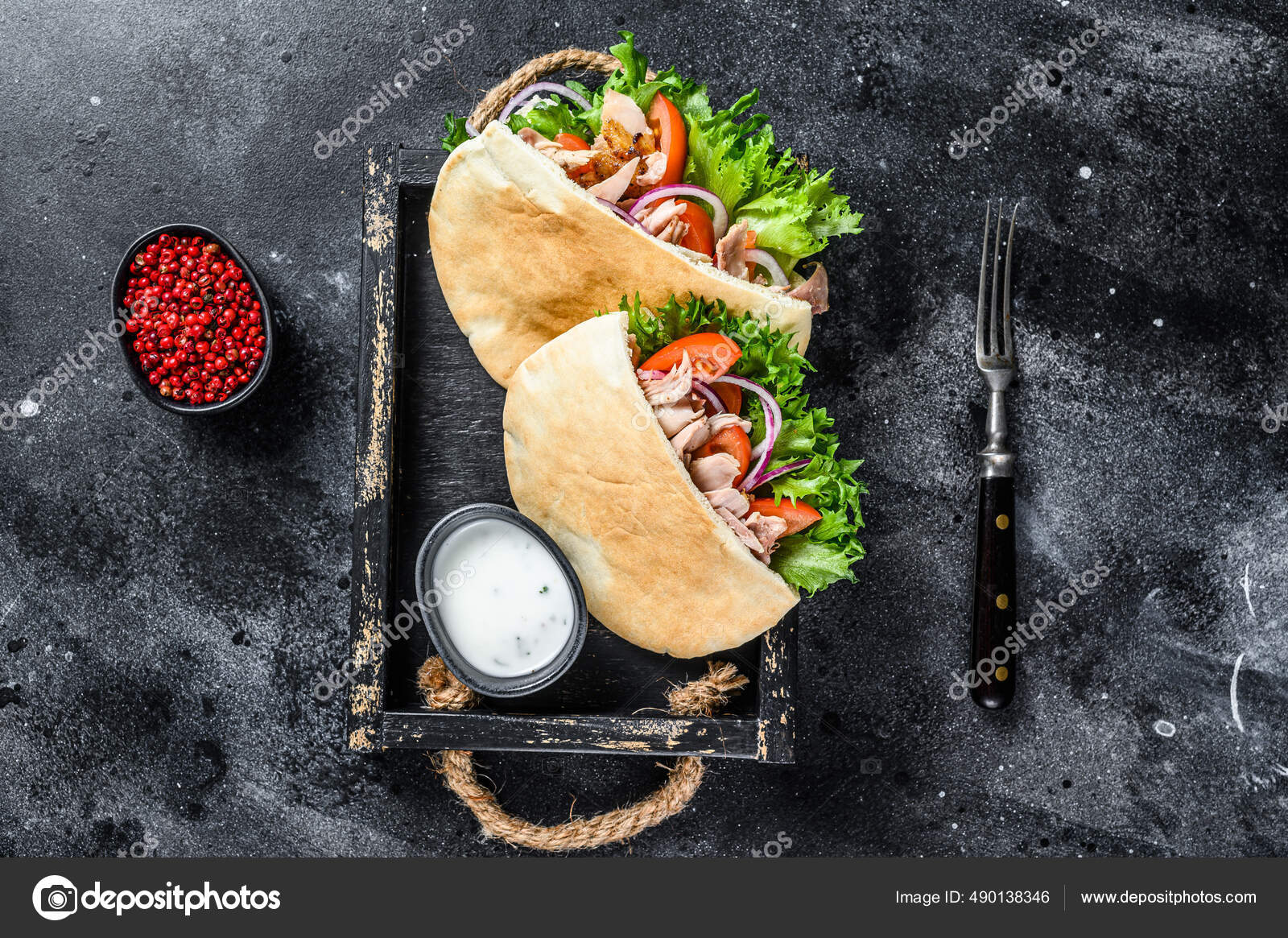 Doner kebab with grilled chicken meat and vegetables in pita bread on a ...