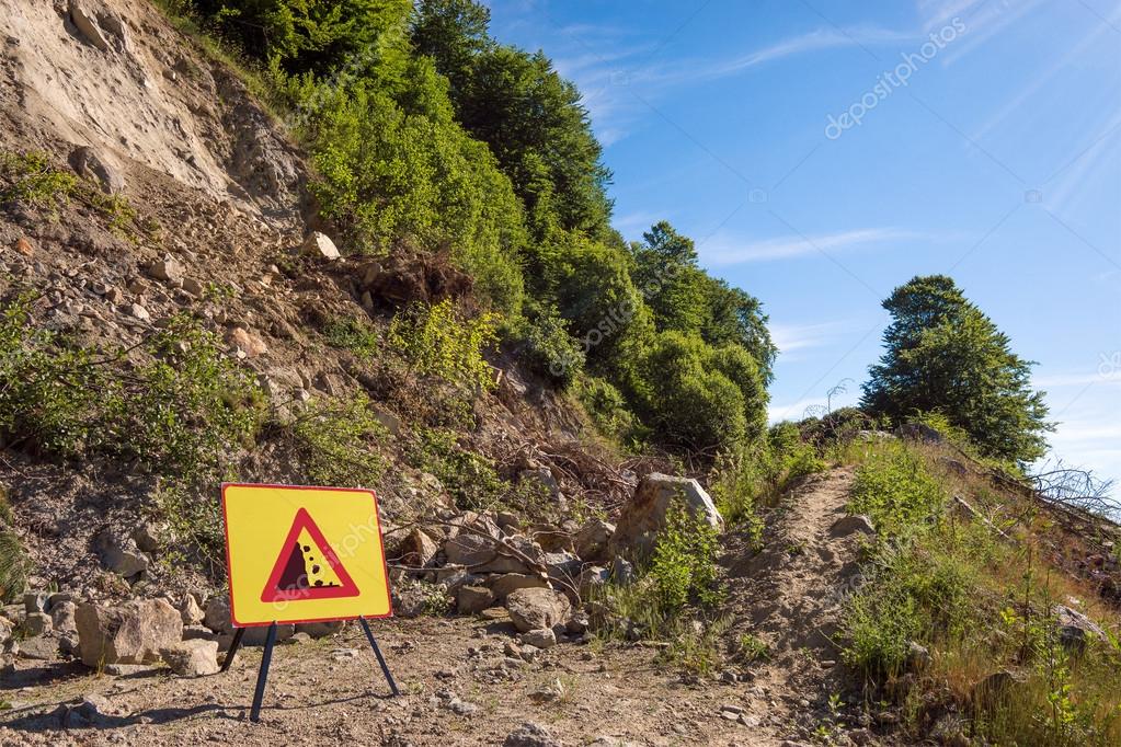 Landslide in forest dirt road and warning sign. — Stock Photo ...