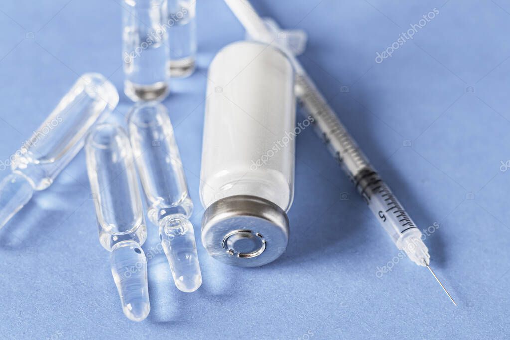 Ampollas médicas inyectables, vial y jeringa sobre fondo azul. Ampollas ...