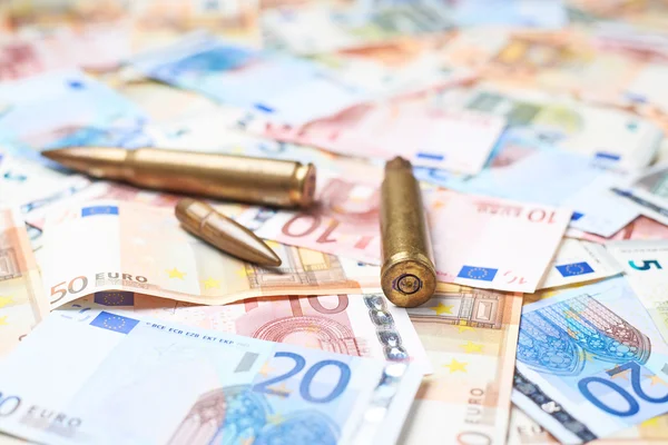 Few bullets over the pile of money - Stock Image - Everypixel