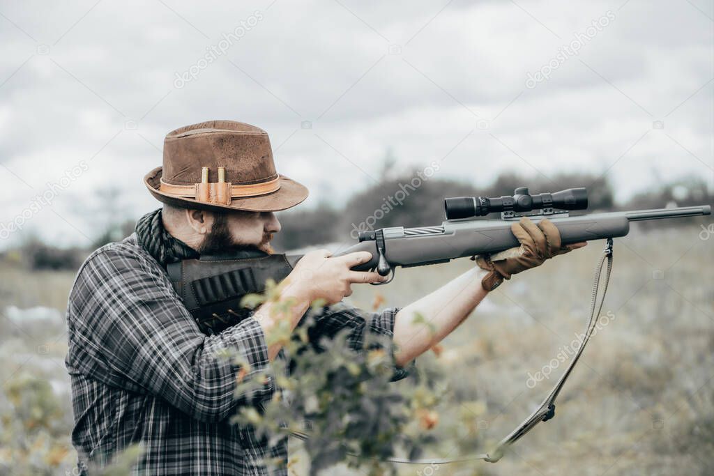 El hombre dispara un rifle. Hombre barbudo con rifle explorador 2024