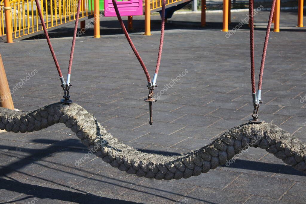 Un fuerte columpio de cuerda con suspensión rota en un parque infantil ...