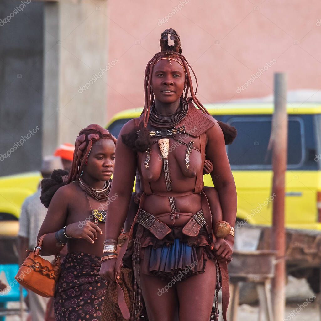 Opuwo, Namibia - 06-jul-2019: Mujeres Himba no identificadas con el típico collar y peinado en ...