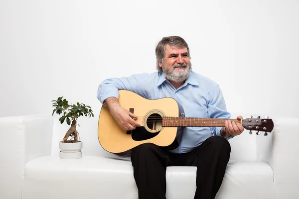 Single old men on white couch with a bonsai - Stock Image - Everypixel