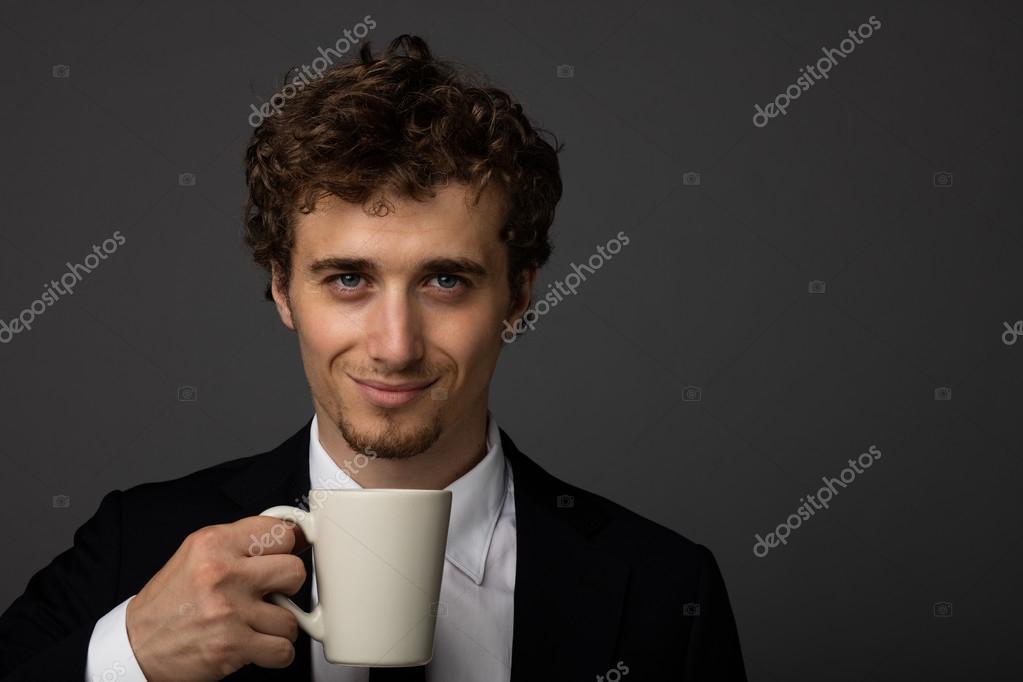 Elegant man in suit with a cup on gray background Stock Photo by ...