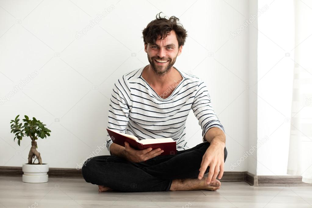Man reading a book and standing on the floor — Stock Photo ...