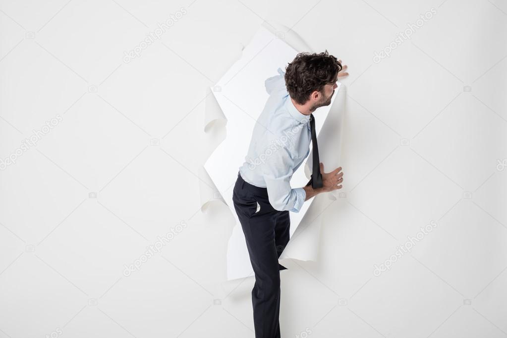 Office man with elegant outfit and tie breaking the paper backgr ...