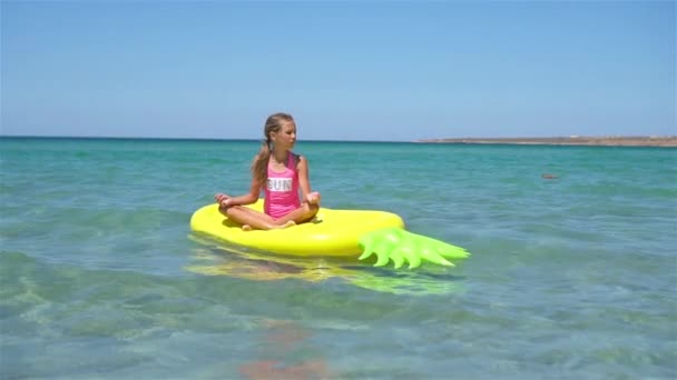 Adorable girl on inflatable air mattress in the sea — Stock Video © d ...
