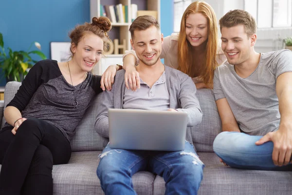 Cuatro amigos se relajan y ven la televisión en la habitación — Foto de ...