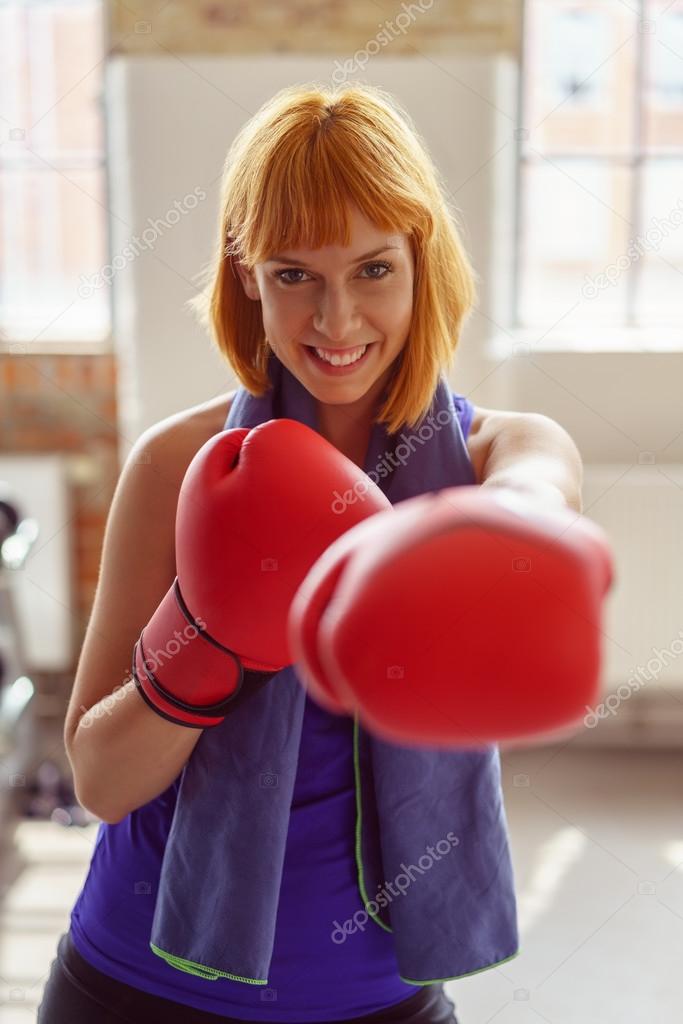 Smiling attractive woman throwing a punch — Stock Photo © racorn #114482854
