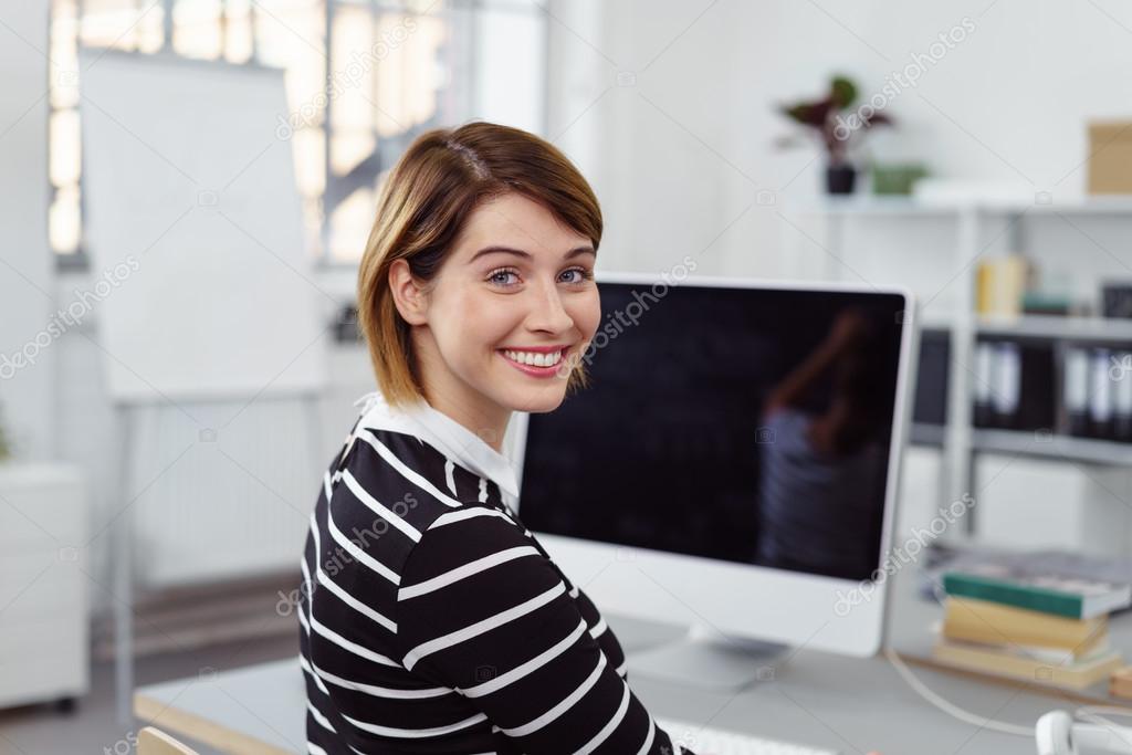 Smiling woman looking over shoulder while working — Stock Photo ...