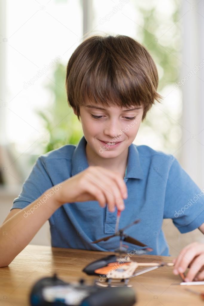 Little boy dismantling an electronic device Stock Photo by ©racorn 55235219