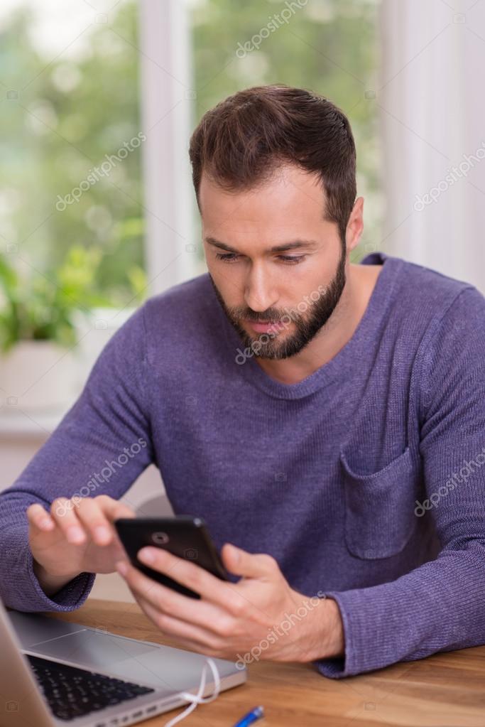 Man reading a message on his smartphone Stock Photo by ©racorn 55774091