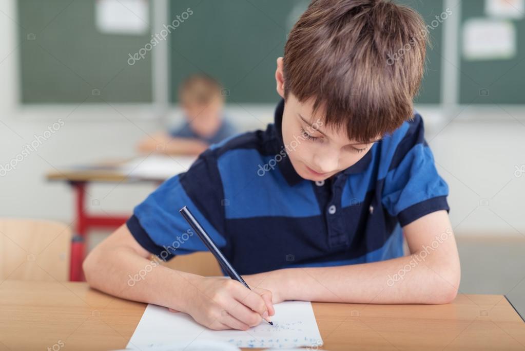 Niño tomando notas en clase en la escuela 2023