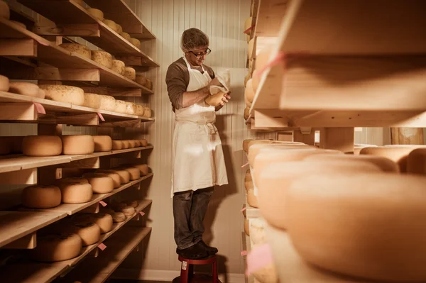 Cheese maker cleaning cheeses in his workshop | Stock Images Page ...