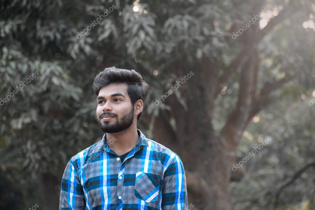 un joven asi tico indio chico mirando el otro lado delante de natural ...