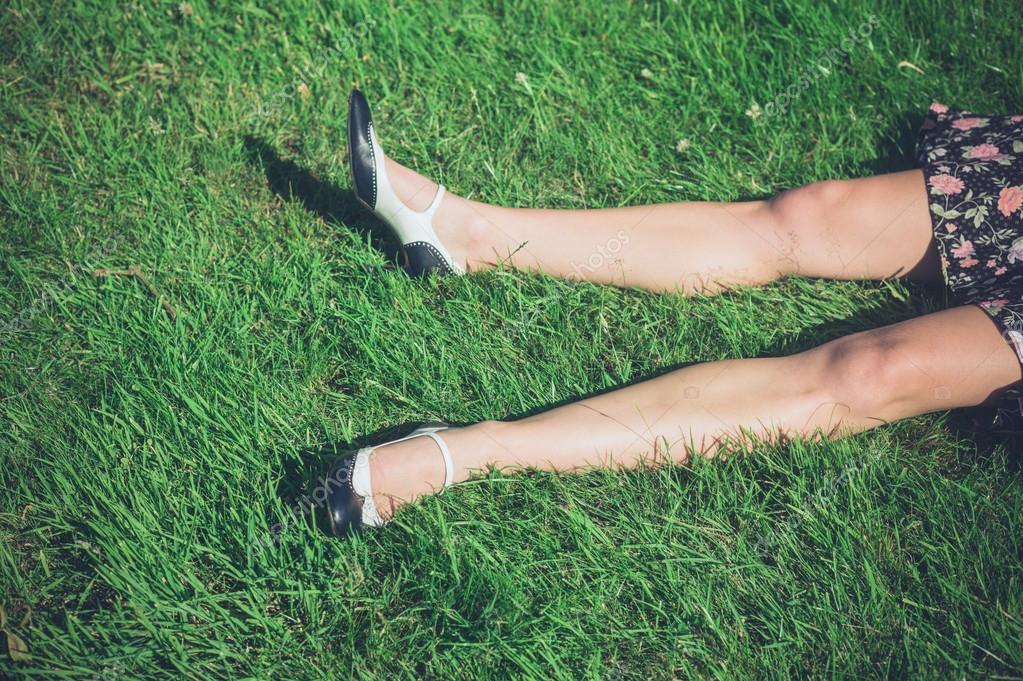 Legs of young woman lying on grass in field — Stock Photo © lofilolo ...