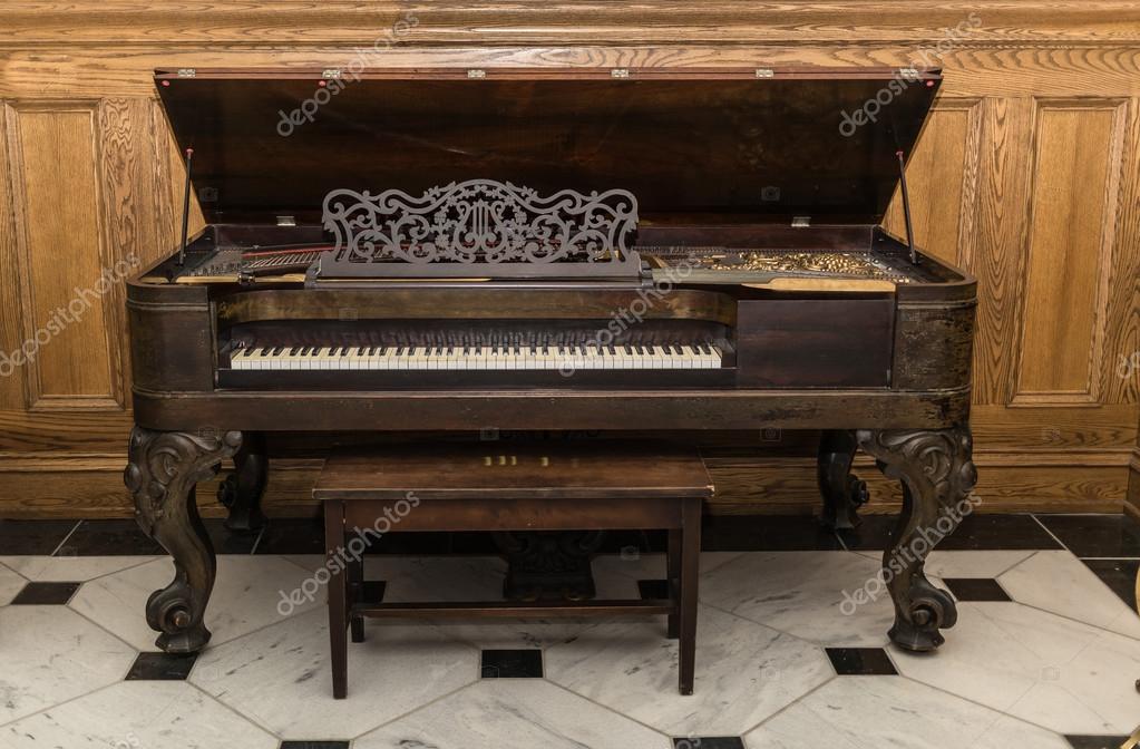 Old beautiful gorgeous vintage grand piano standing against wooden ...