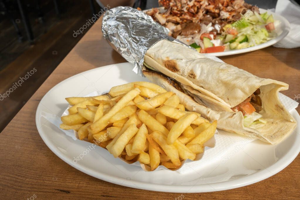 Receta de Kebab y papas fritas en una mesa de platos blancos en un país ...