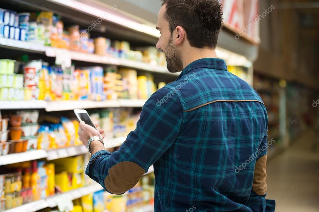 Man Using Mobile Phone While Shopping In Supermarket — Stock Photo ...