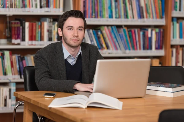 Young Student Using His Laptop In A Library - Stock Image - Everypixel